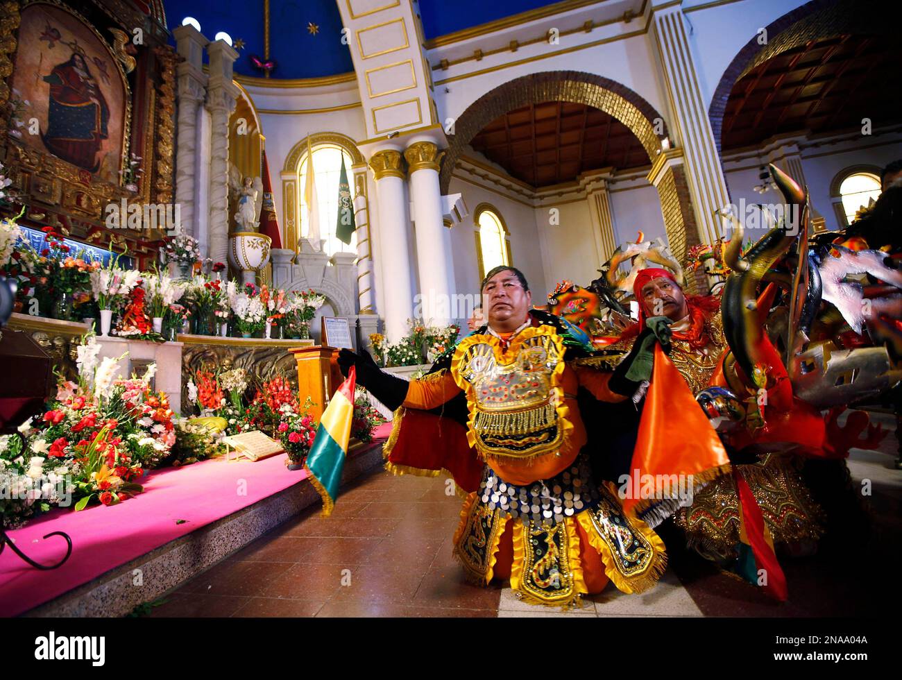 Devil dancers kneel before their patron saint the "Virgen del Socavon ...
