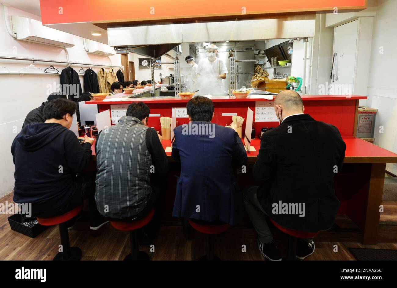 Japanese men eating Ramen in a small restaruant in Nishishinjuku, Tokyo ...