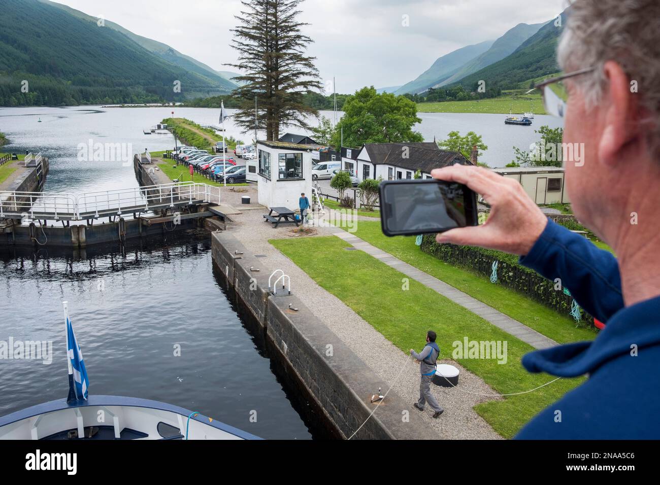 A traveler aboard a boat photographs The Caledonian Canal near Loch ...