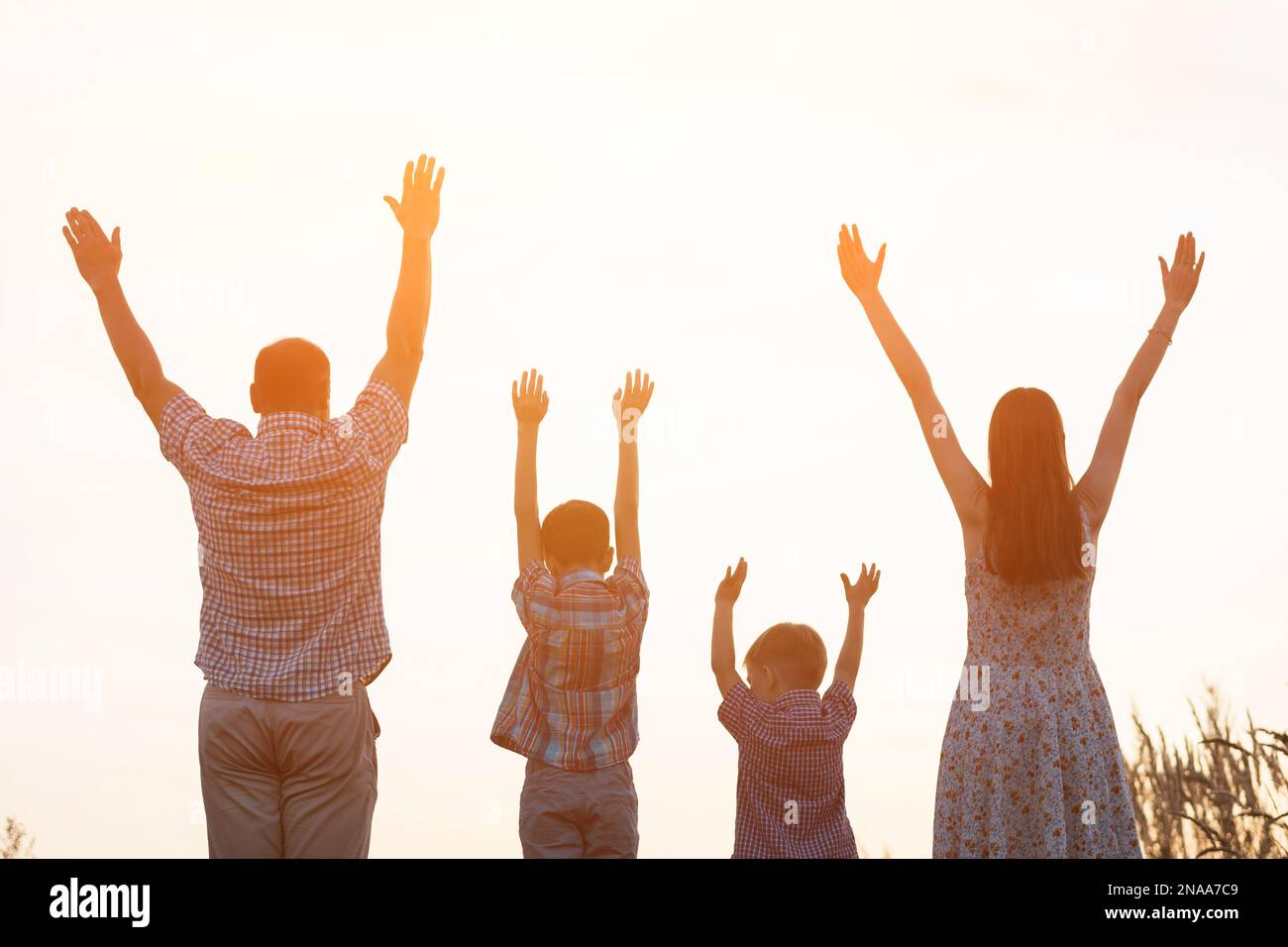 Parents and kids silhouettes raise hands to sky Stock Photo - Alamy
