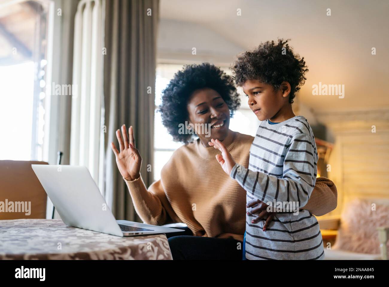 Happy black family gathering around notebbok and having fun during a ...