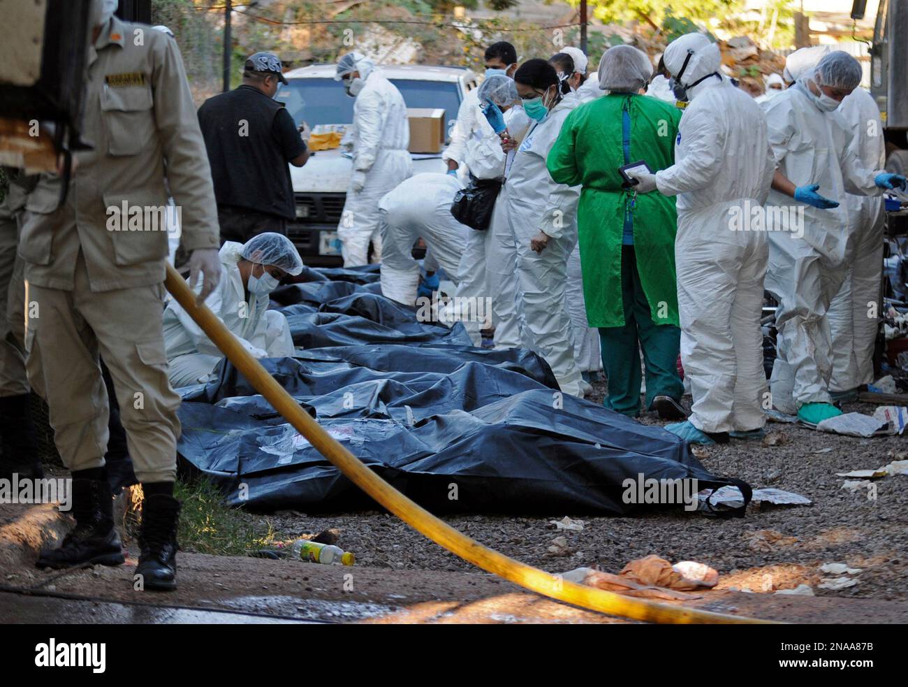 Forensic workers begin the process of identifying bodies of inmates ...