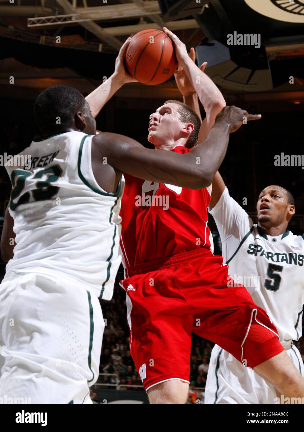 Wisconsin's Jared Berggren, center, shoots between Michigan State's ...