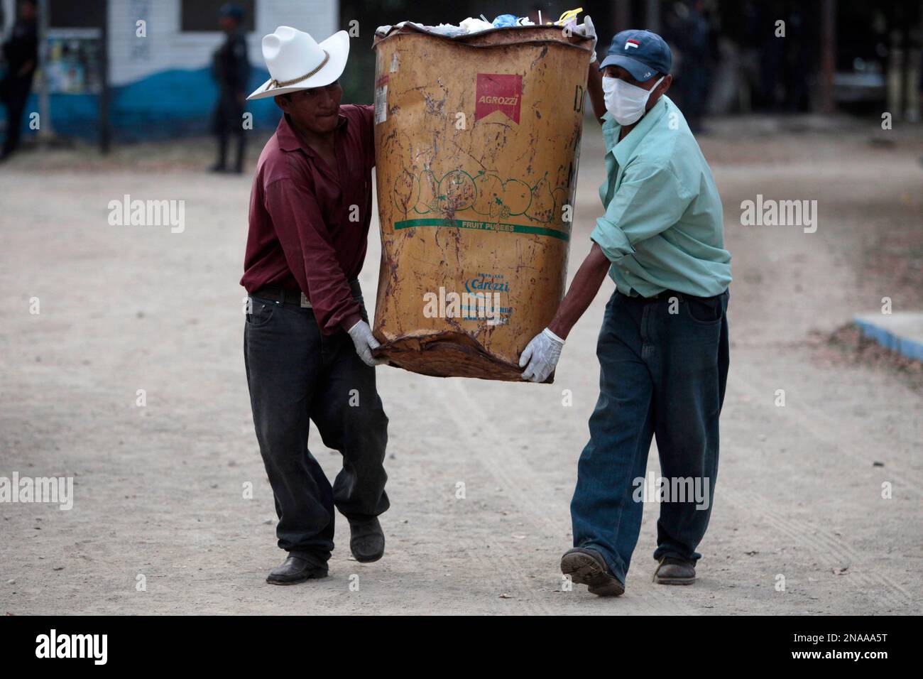 Inmates who survived a deadly prison fire carry garbage as they clean ...
