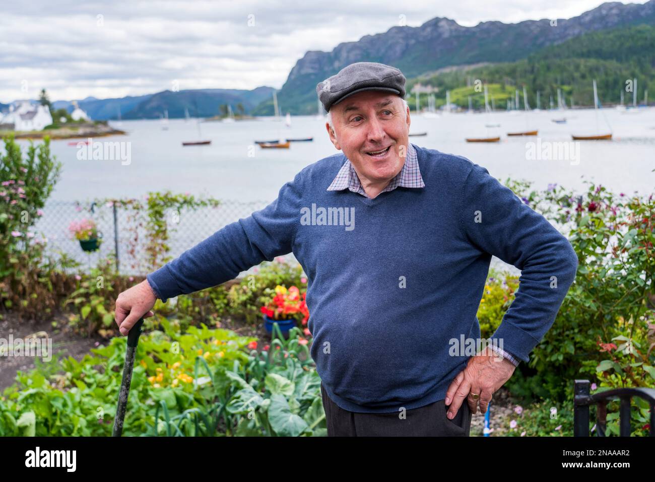 A Scottish man poses for a portrait in his garden; Plockton, Scotland ...