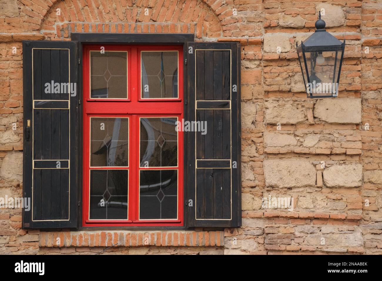 vintage wooden window on the ancient facade. old lantern on the wall ...