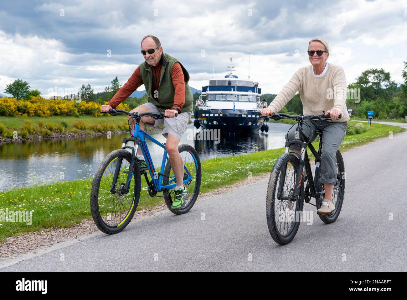 A man and woman ride bicycles along the Caledonian Canal tow path near ...