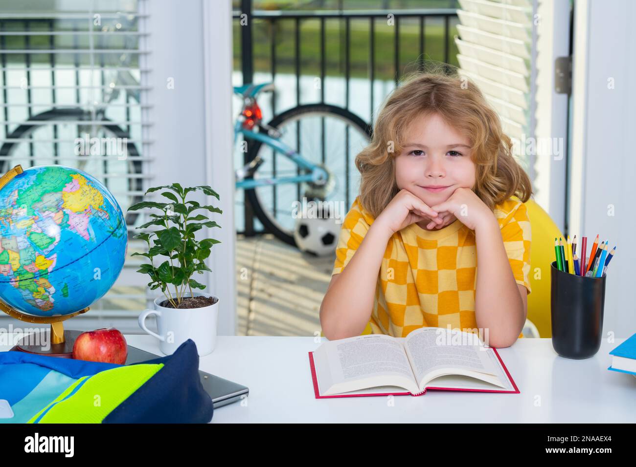 Child reading book. School child studying in classroom at elementary ...