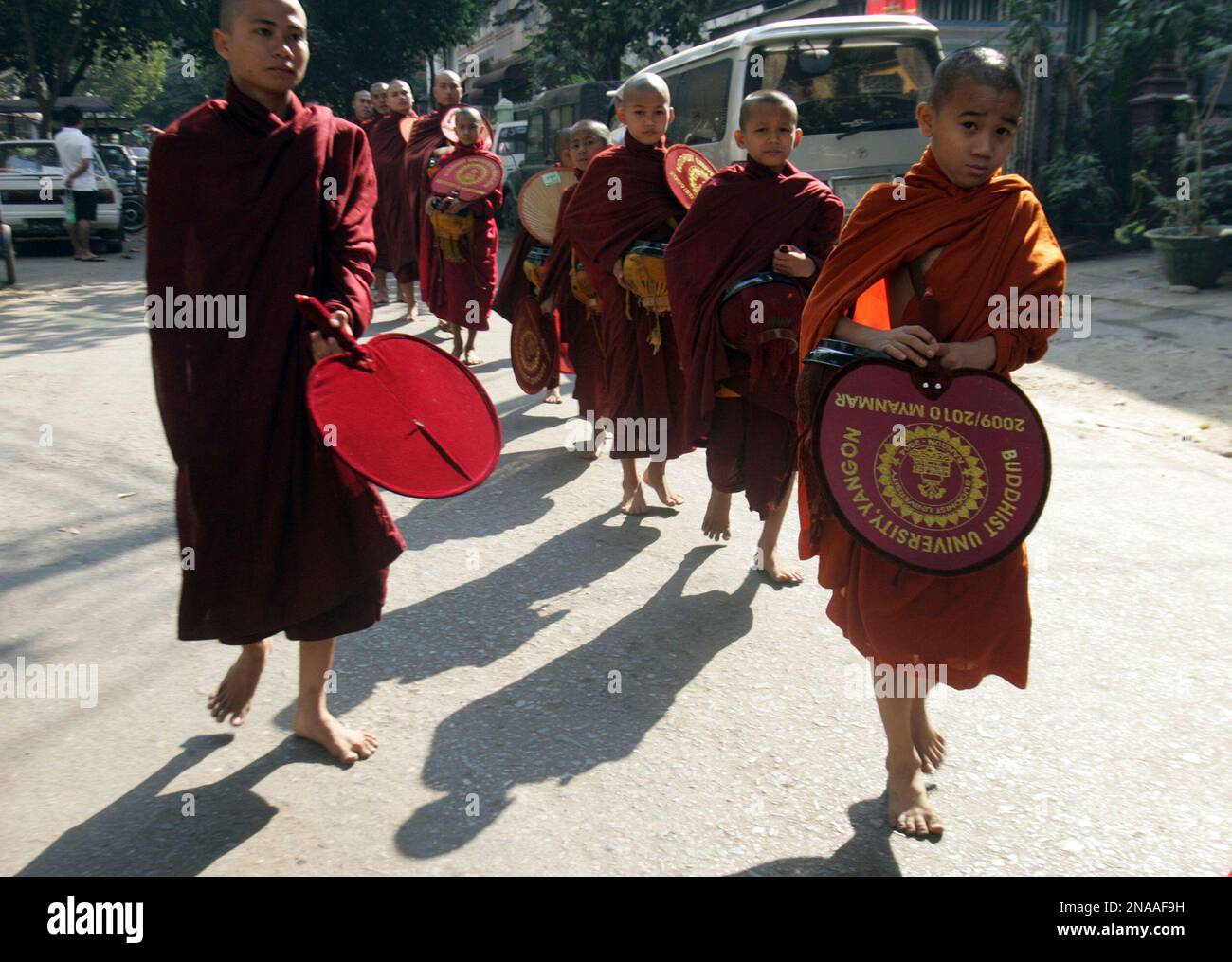 Myanmar Buddhist monks walk in a line to collect alms from devotees ...