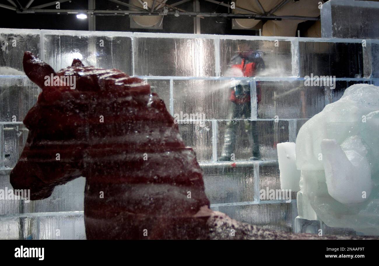 A Chinese worker cuts an ice block in the construction site of an ice ...