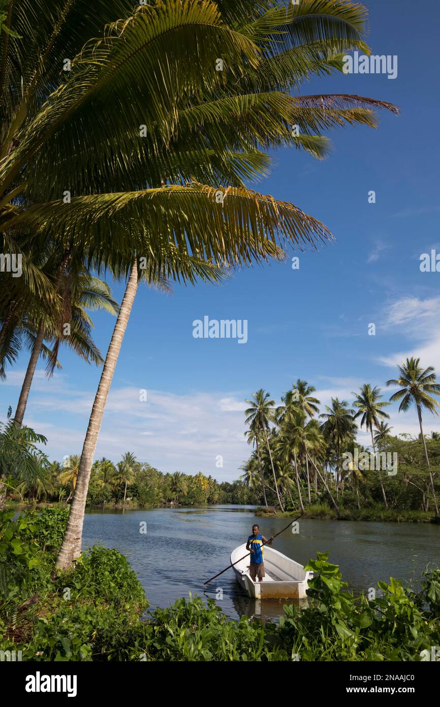 Man in boat on river flowing from the interior into the Solomon Sea at ...