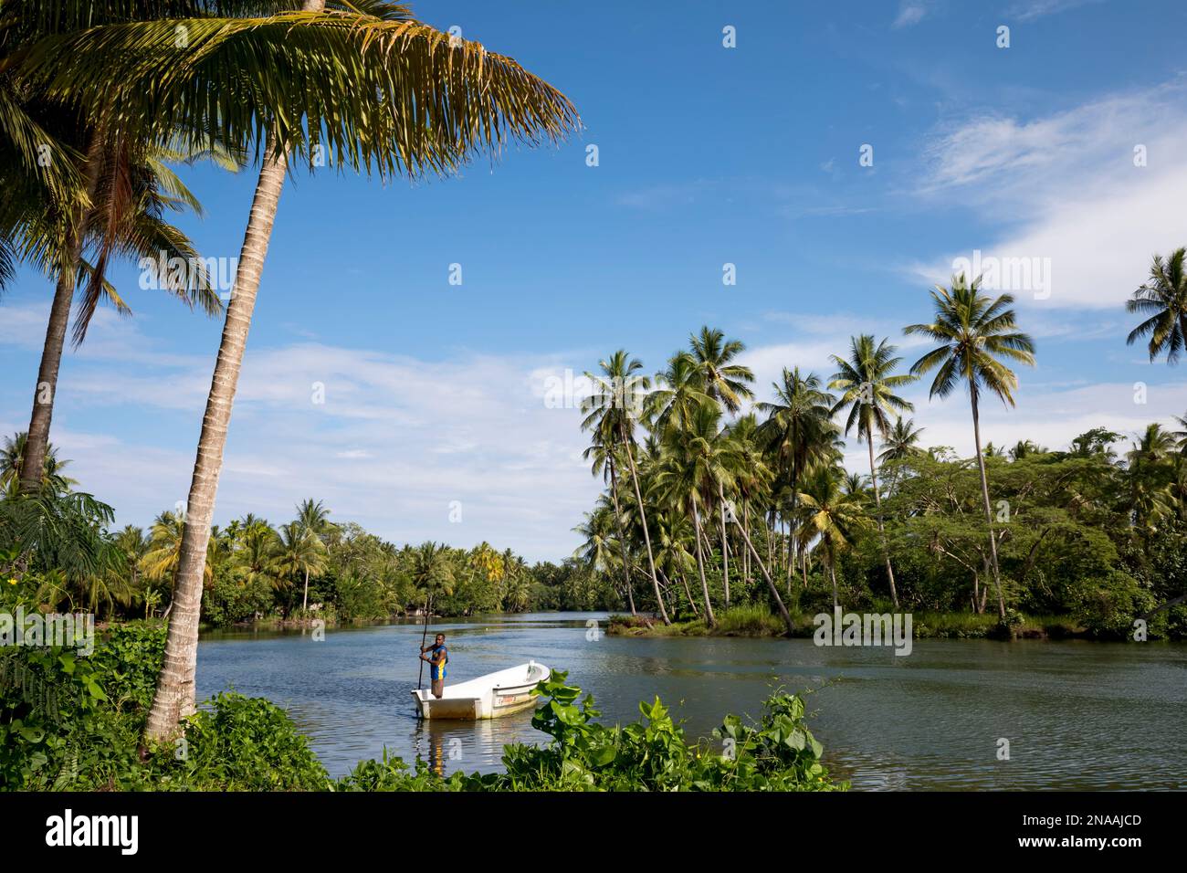 Man in boat on river flowing from the interior into the Solomon Sea at ...
