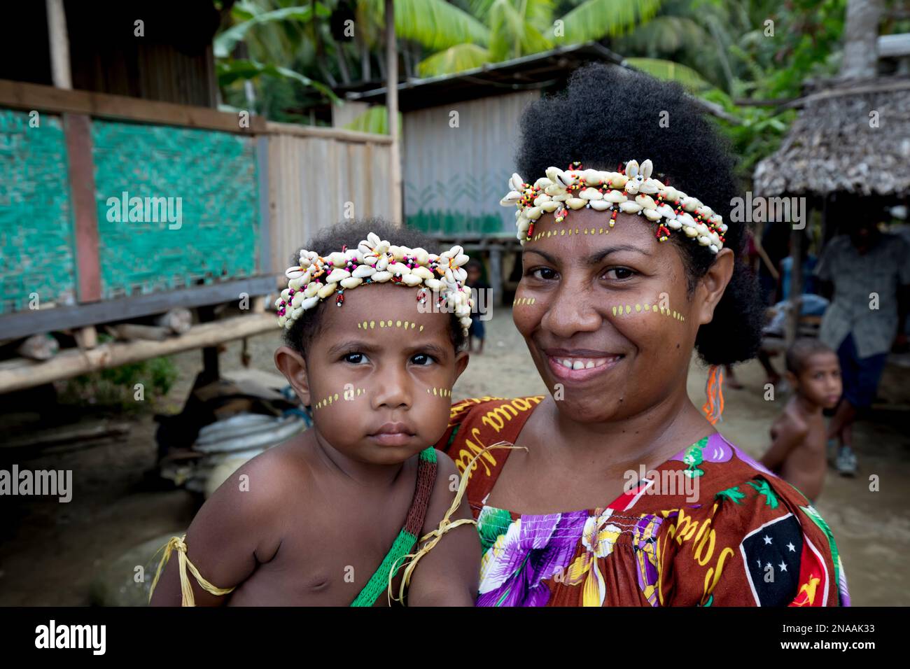 Mother and child with sea shell headbands on the shore of Siboma ...