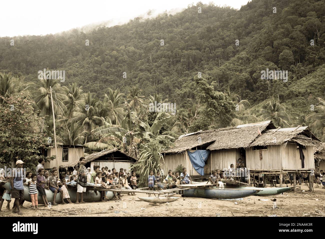 Villagers with boats and houses on stilts on the shore of Siboma ...