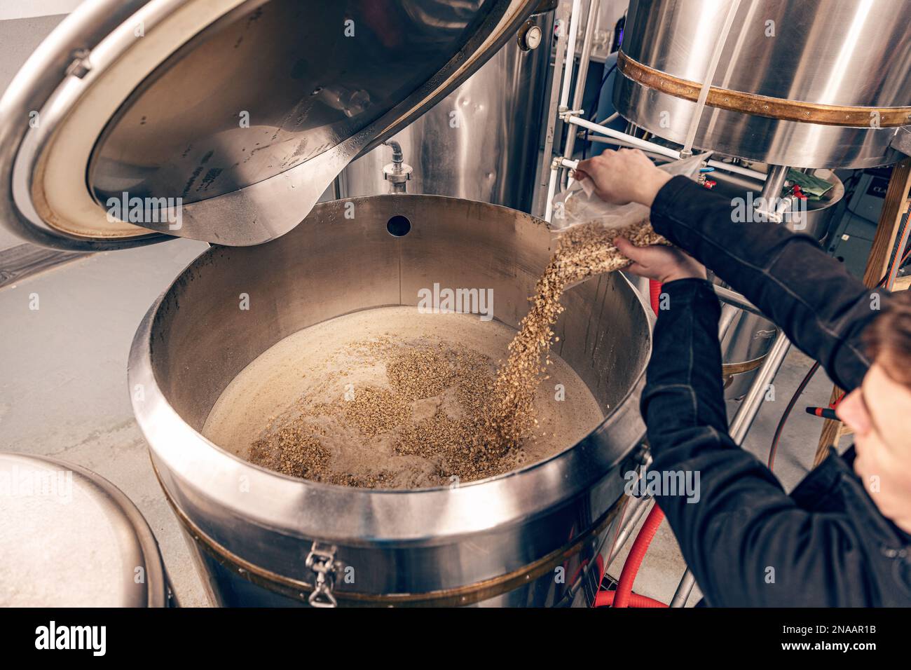 Worker pours ingredients into a brewing vat Stock Photo - Alamy