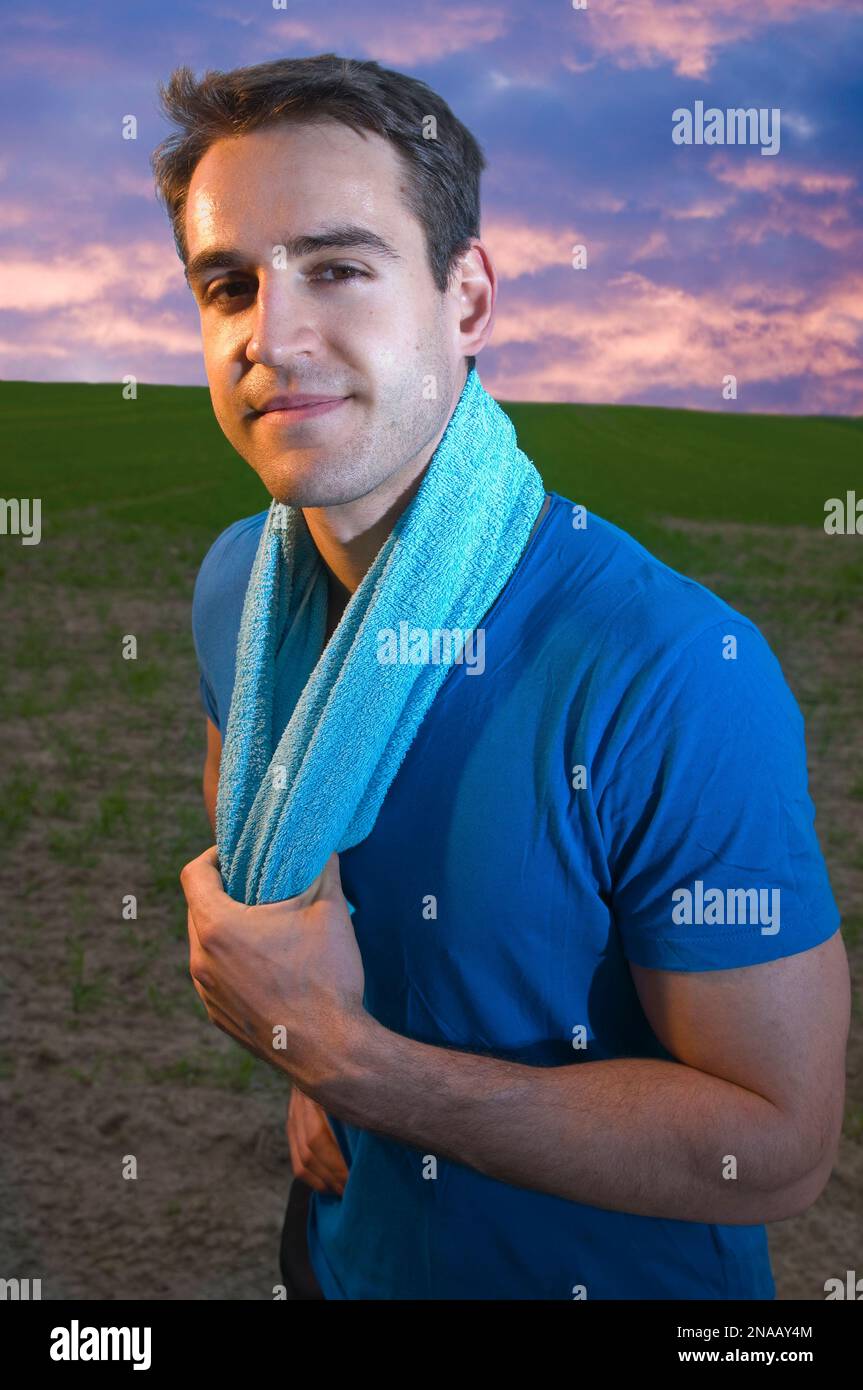 Three-quarter upper body view of a young man in sportswear and a blue ...