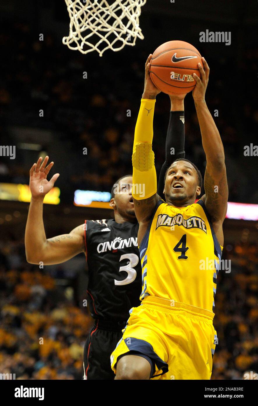 Cincinnati's Dion Dixon (3) defends as Marquette's Todd Mayo (4) drives ...