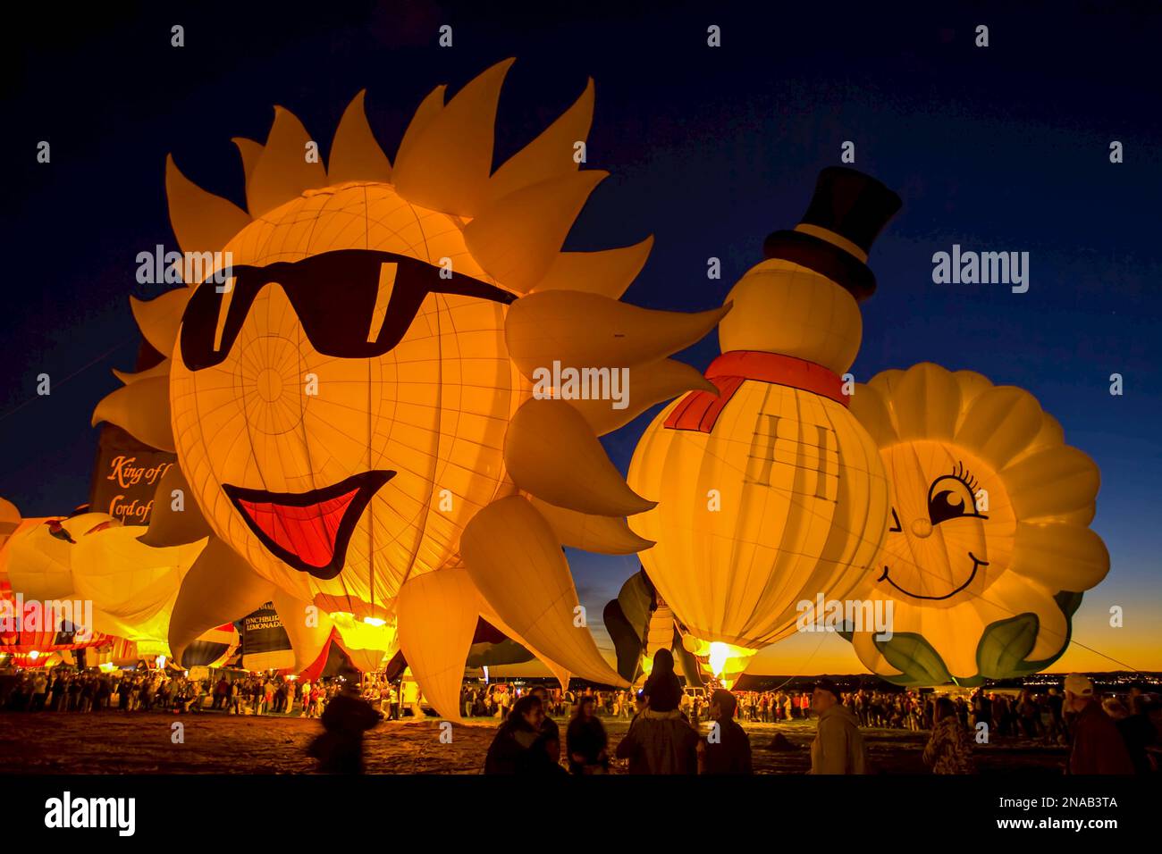 Several hot air balloons float above a crowd at a Balloon Fiesta Stock ...