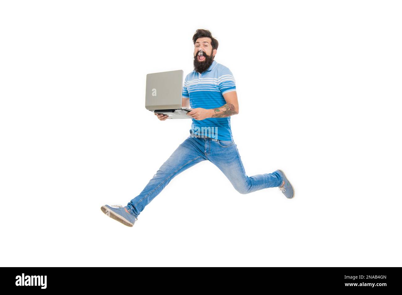 Excited man midair isolated on white. Bearded man jumping with laptop ...