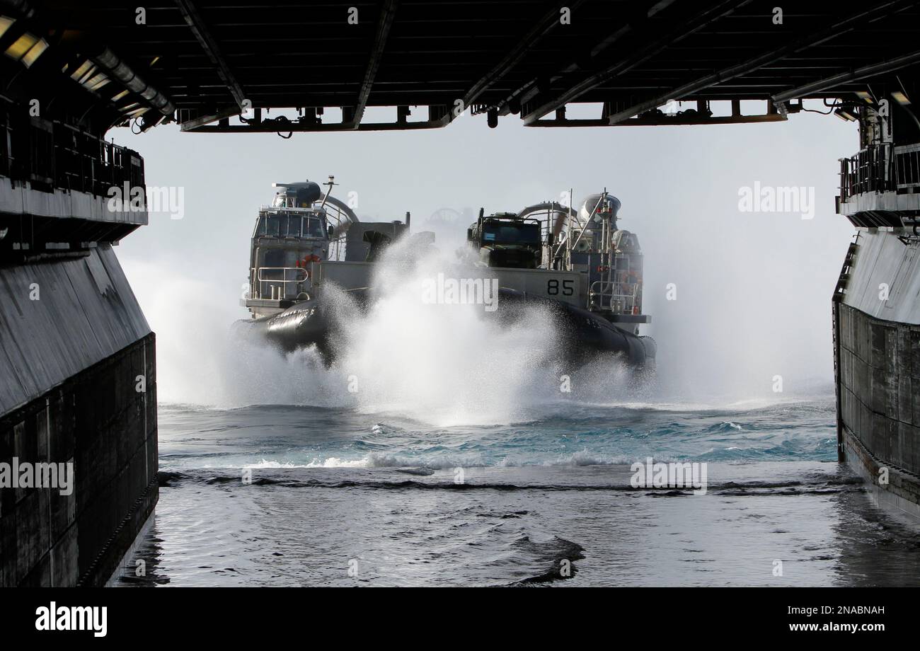 A LCAC loaded with artillery and trucks approaches the well deck during ...