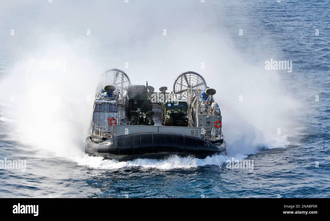 A LCAC loaded with artillery and trucks approaches the well deck during ...