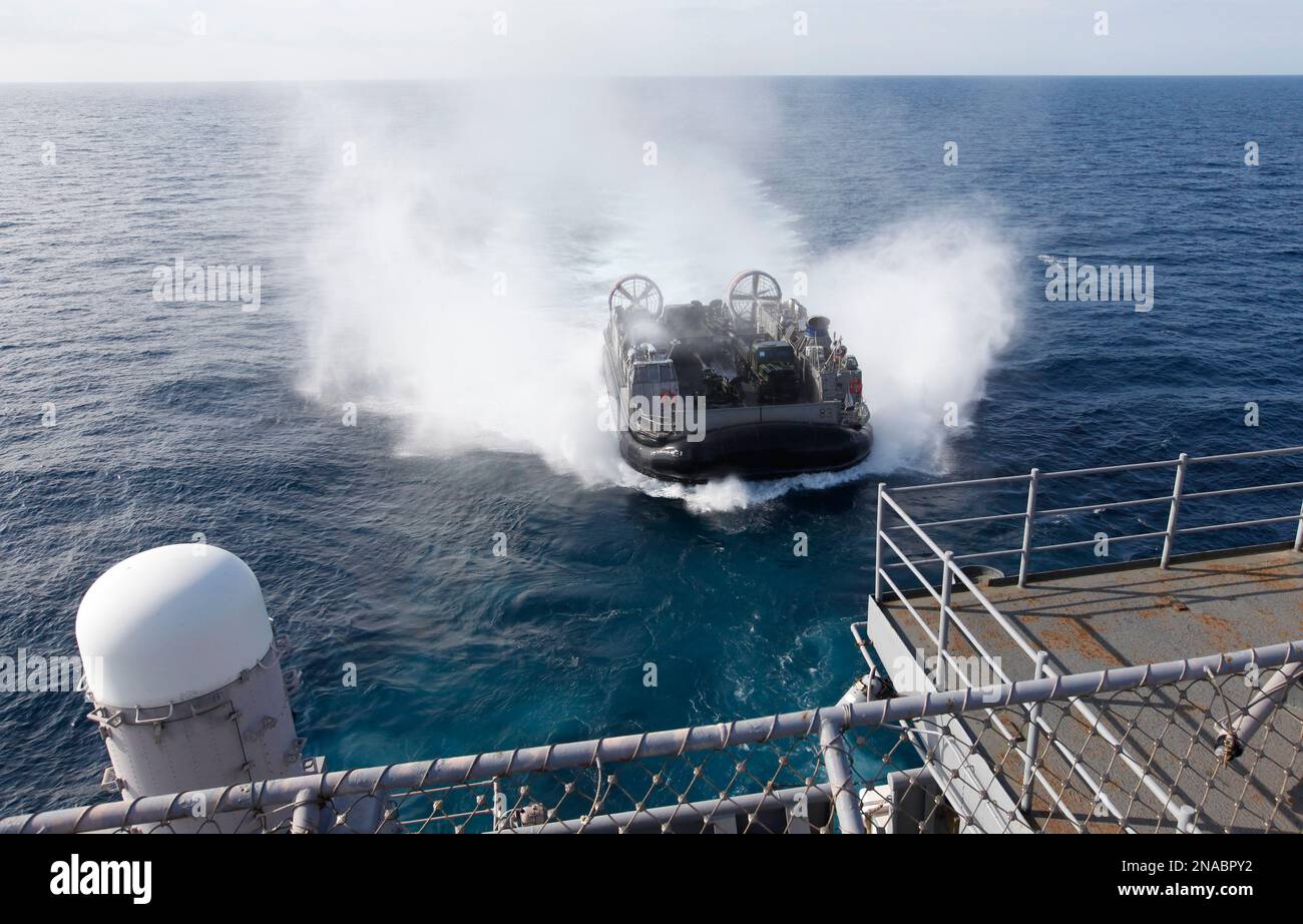 A LCAC loaded with artillery and trucks approaches the well deck during ...