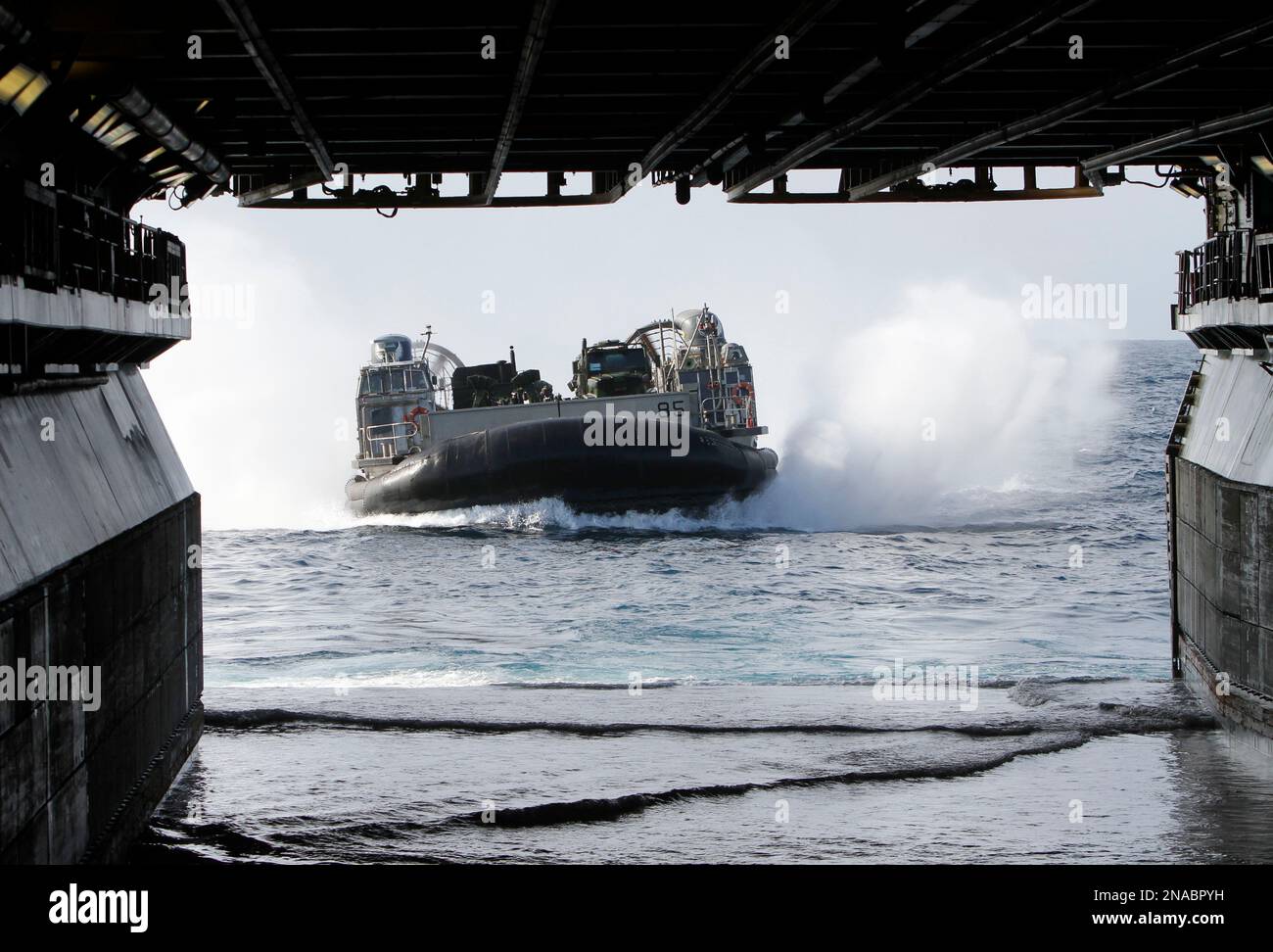 A LCAC loaded with artillery and trucks approaches the well deck during ...