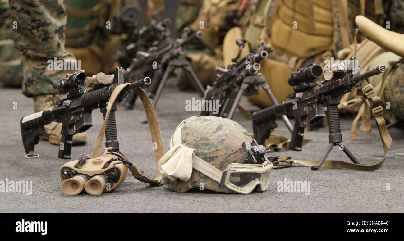 In this Feb. 4, 2012 photo, Marines lay their weapons on the deck as ...
