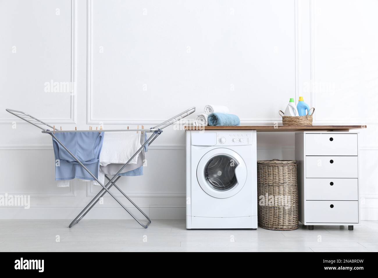 Clean laundry hanging on drying rack indoors Stock Photo - Alamy