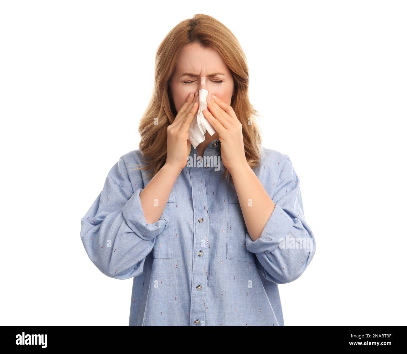 Woman with tissue suffering from runny nose on white background Stock ...