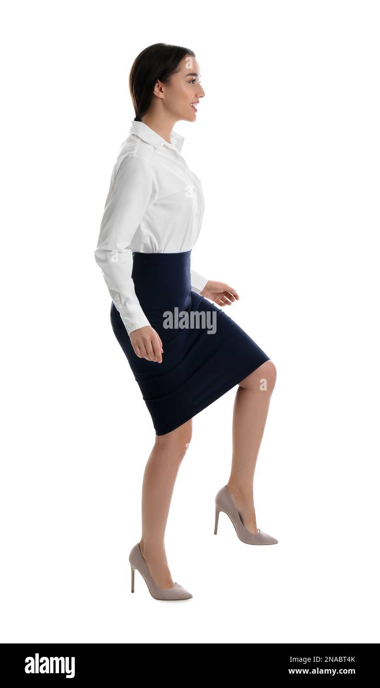 Businesswoman imitating stepping up on stairs against white background ...