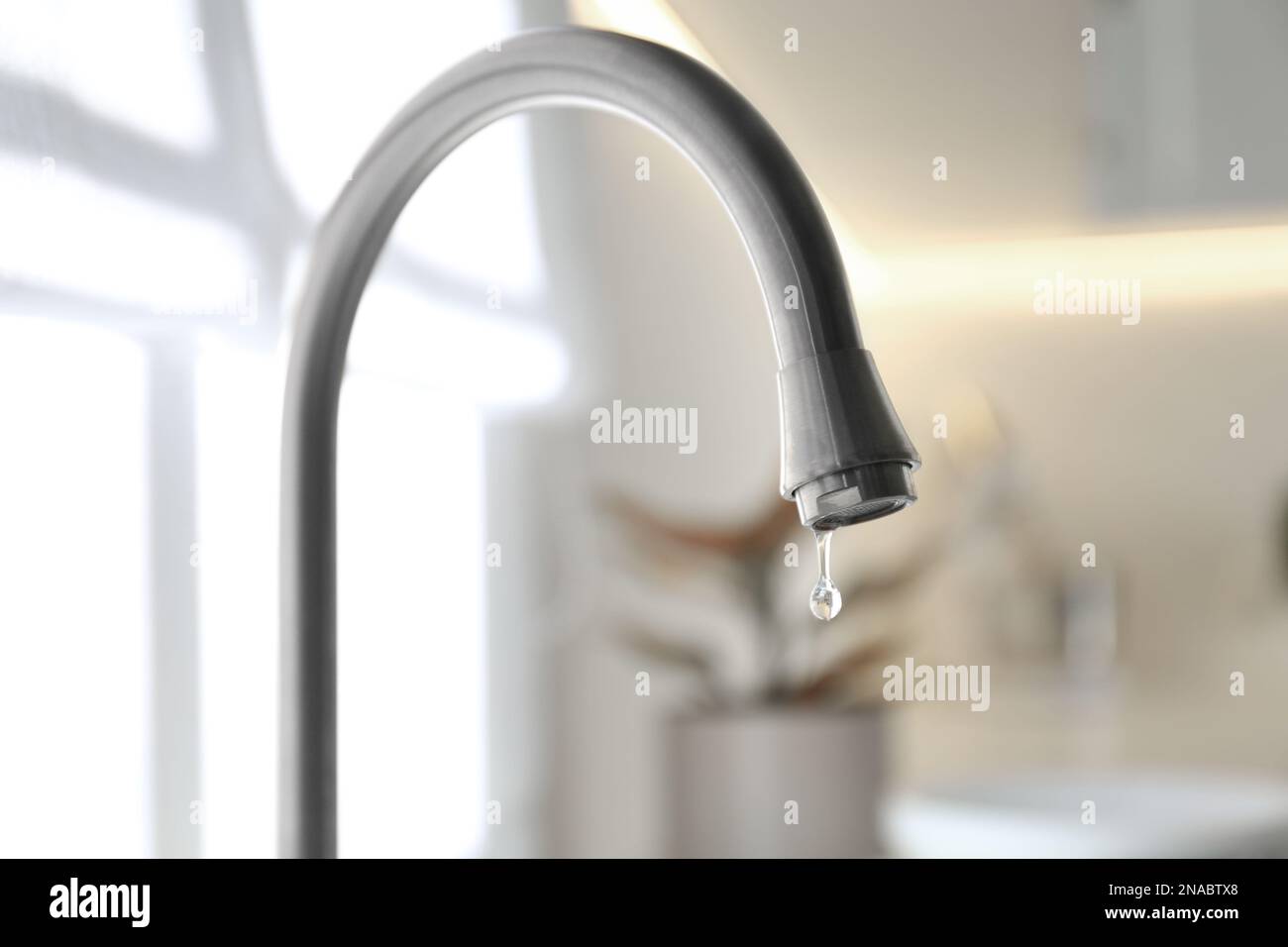 Water drop falling down from tap on blurred background, closeup Stock ...