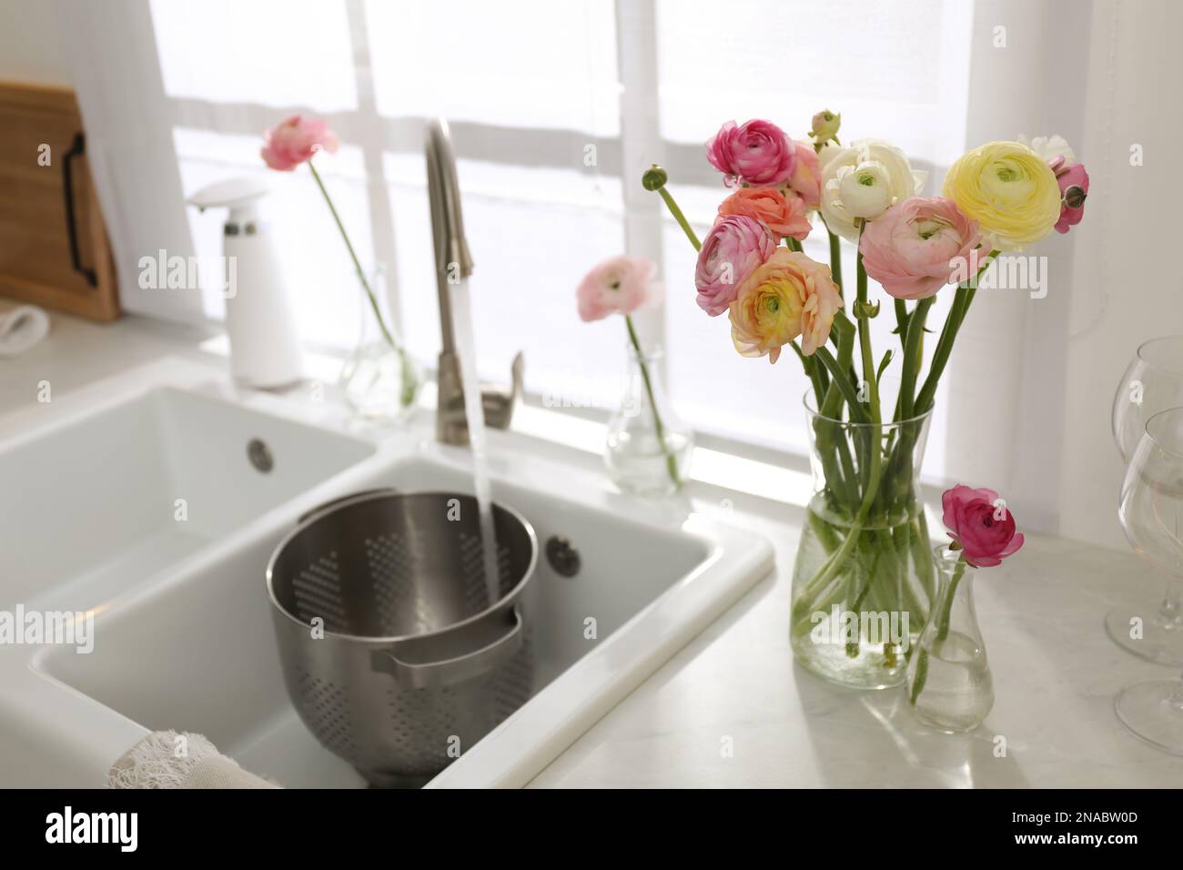 Light kitchen decorated with beautiful fresh ranunculus flowers Stock ...