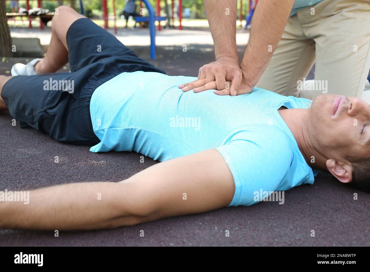 Passerby performing CPR on unconscious man outdoors. First aid Stock ...