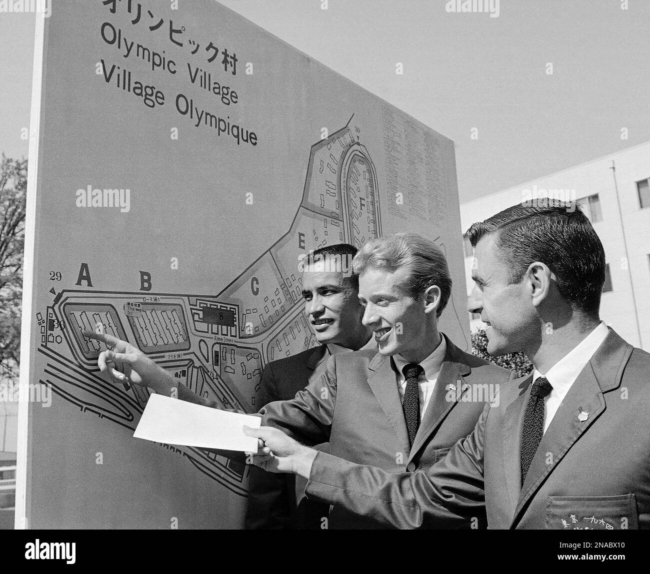 Three members of the U.S. Olympic track and field team look over a map ...