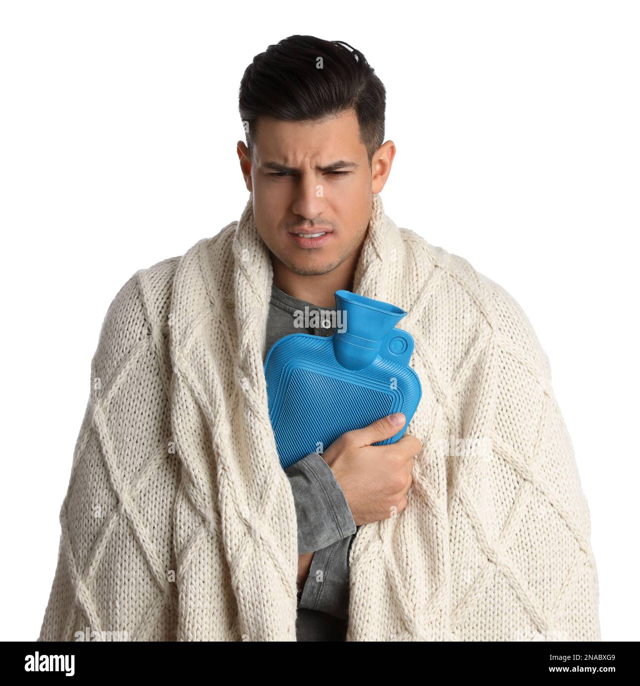 Ill man with hot water bottle suffering from cold on white background ...