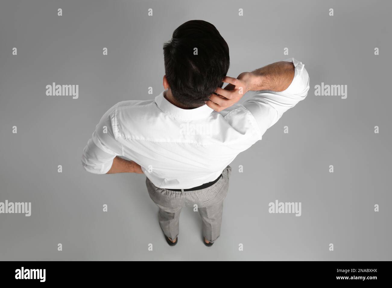 Businessman in formal clothes on grey background, back view Stock Photo ...