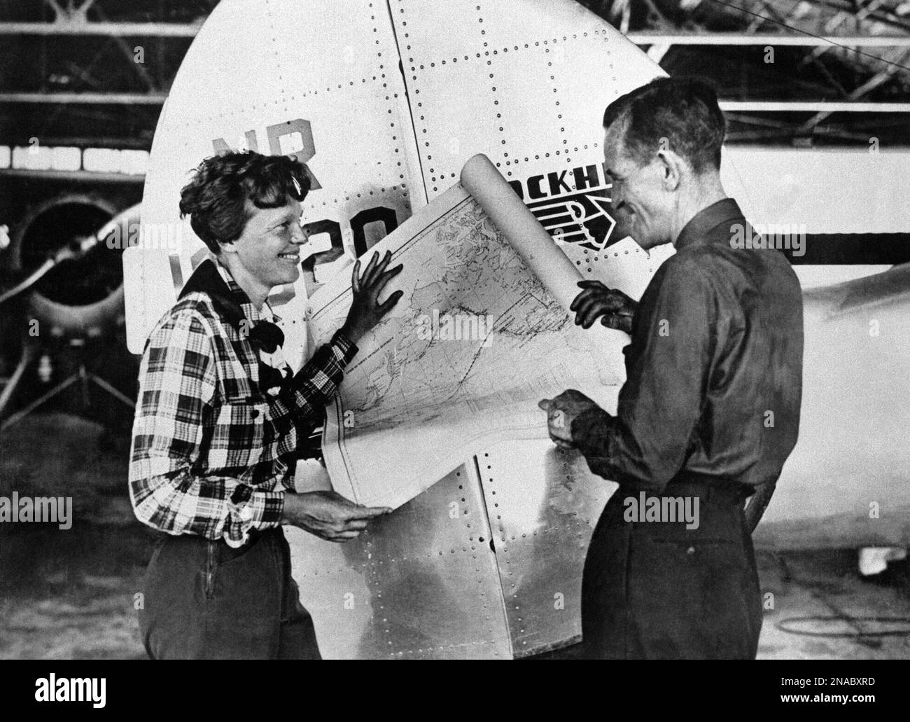 Aviation pioneer Amelia Earhart and navigator Fred Noonan pose with map ...