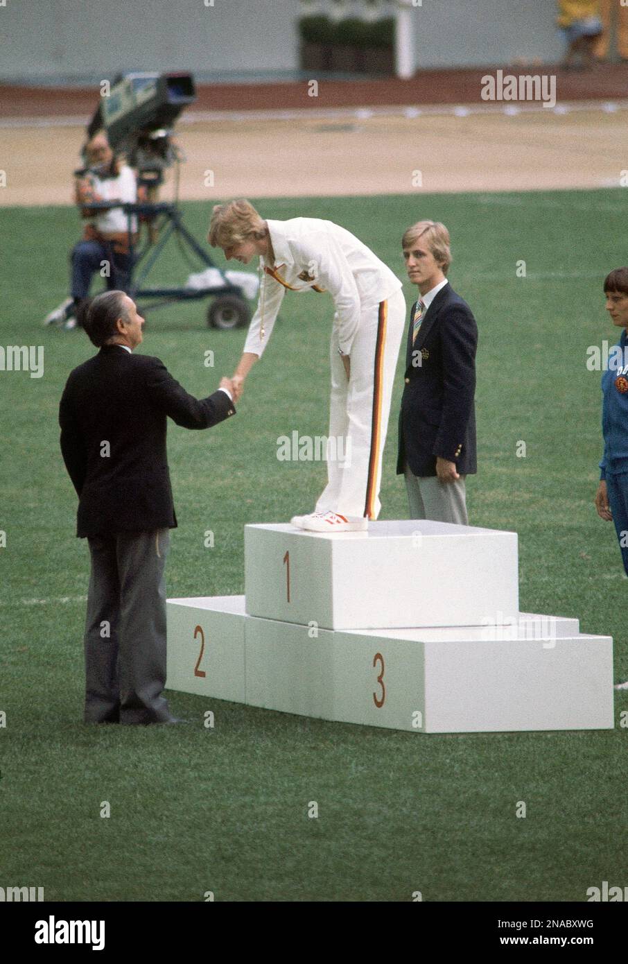 West Germany's Annegret Richter shaking hands on the podium after ...