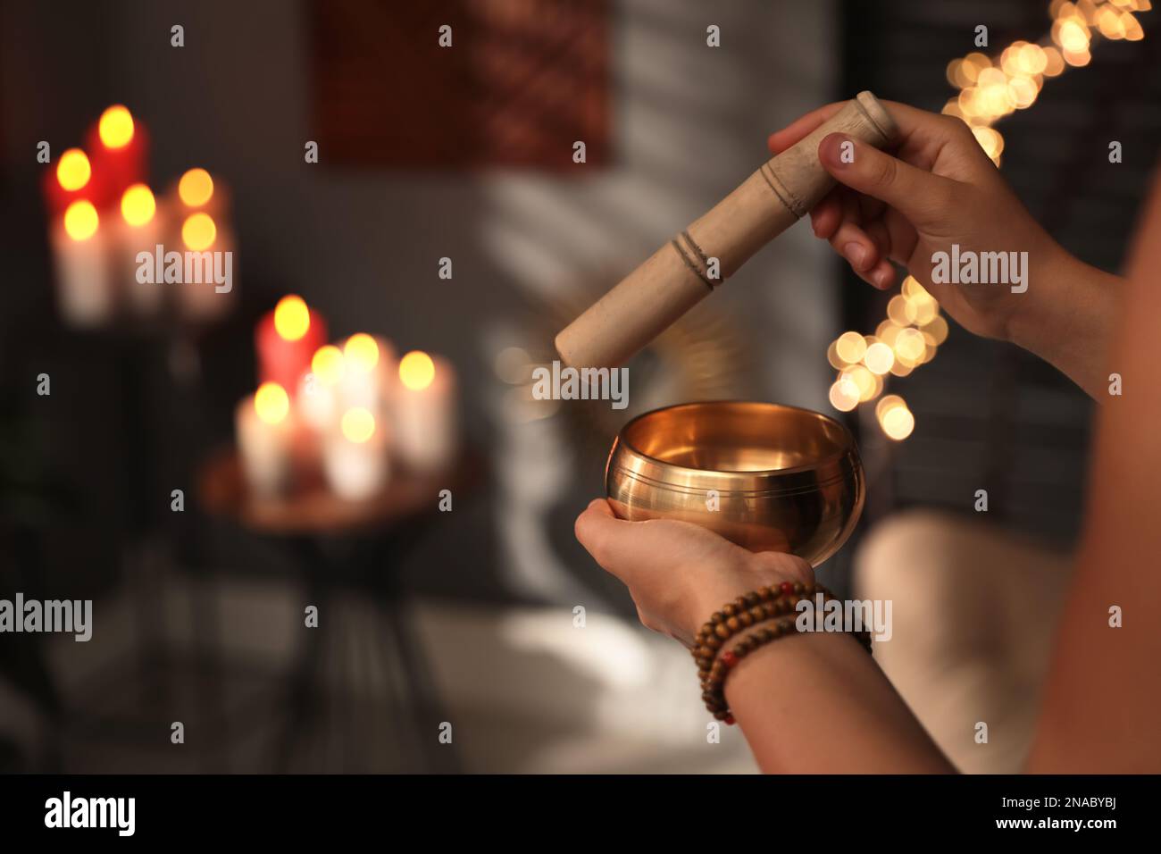 Healer using singing bowl in dark room, closeup Stock Photo - Alamy