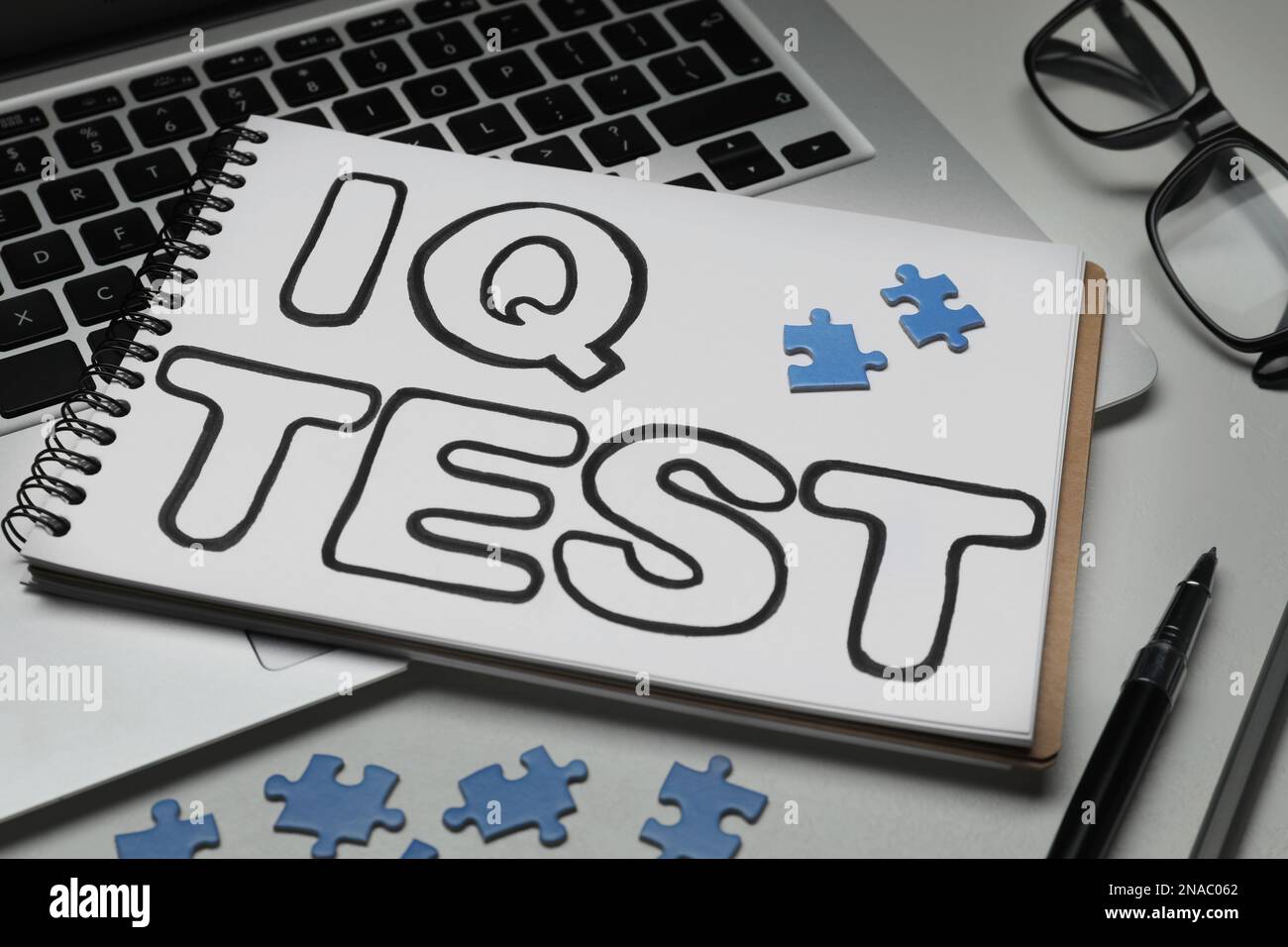 Notebook with words IQ Test, puzzles and laptop on white table Stock ...