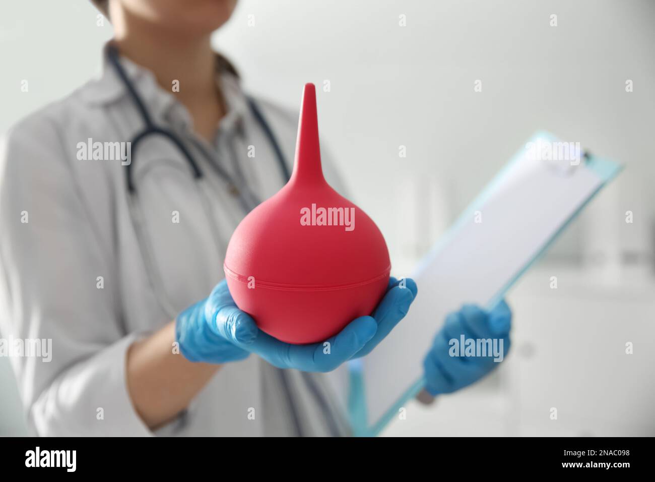 Doctor holding pink enema in hospital, closeup Stock Photo - Alamy