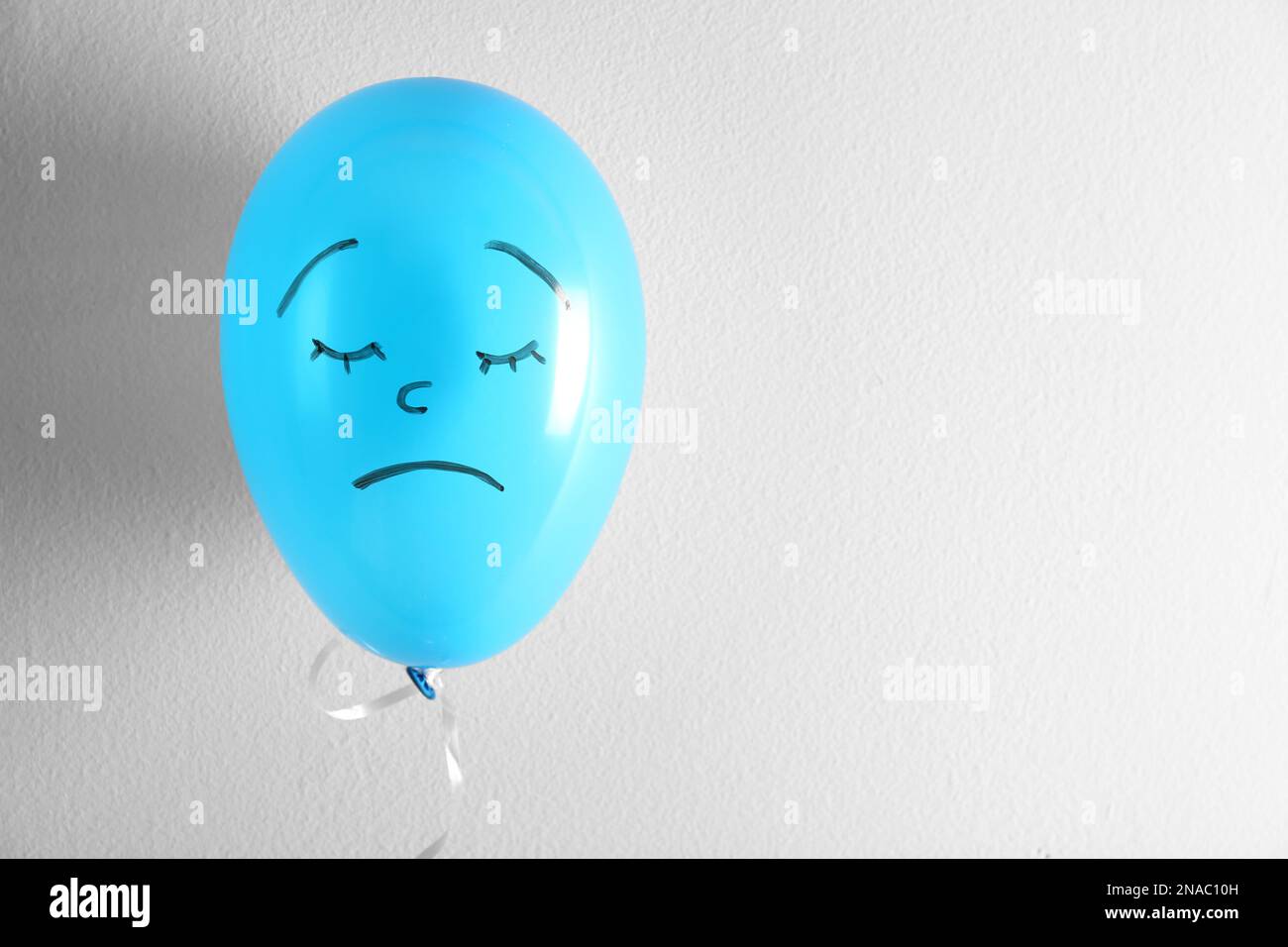Air balloon with drawn sad face on white background. Space for text ...