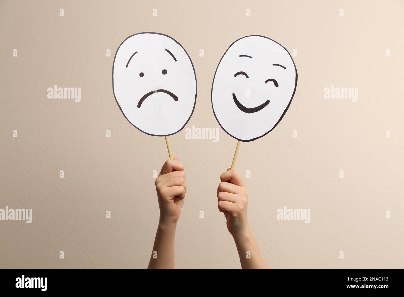 Woman with sad and happy paper faces on beige background, closeup Stock ...