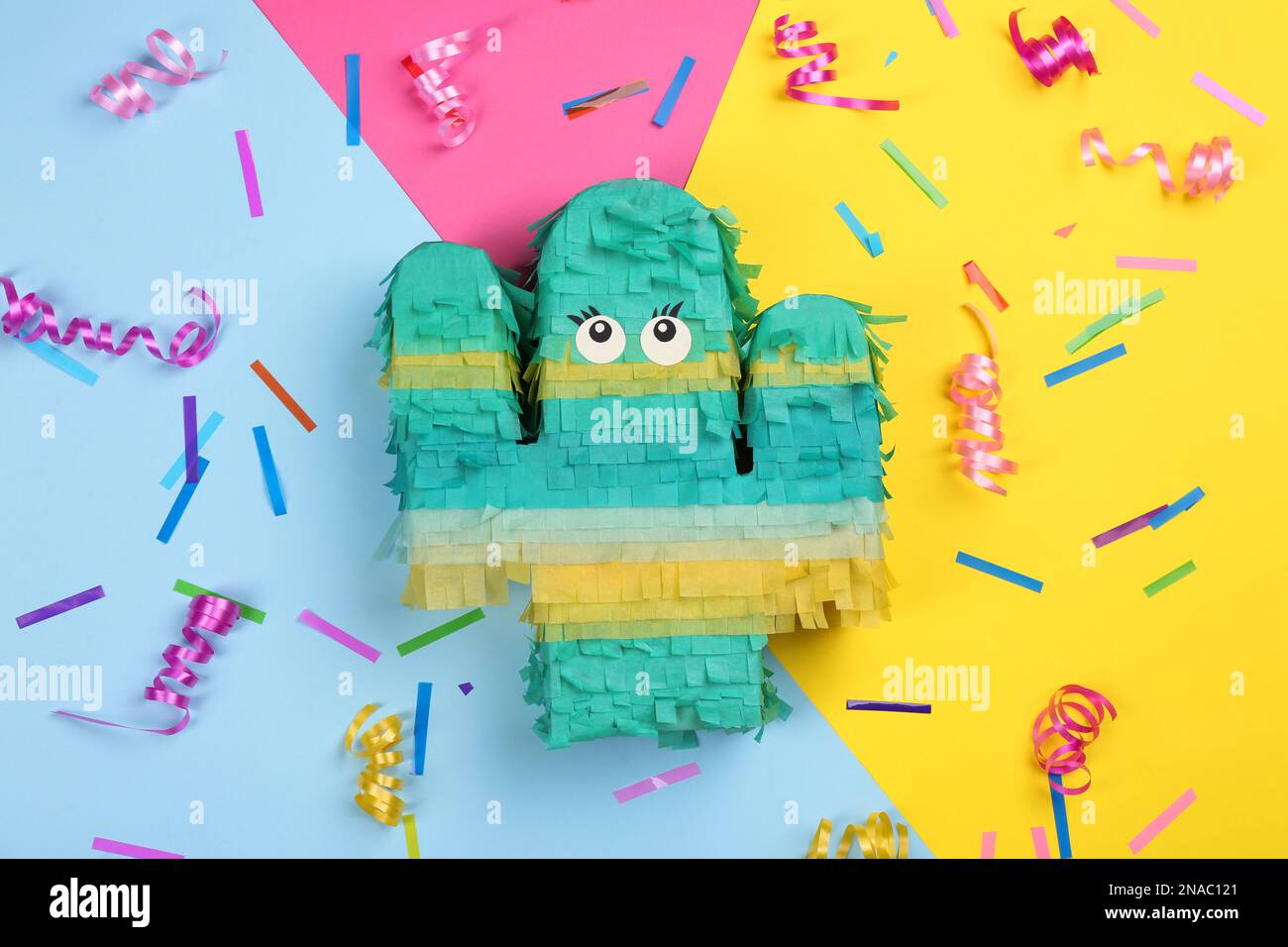 Cactus shaped pinata, streamers and glitter on color background, flat ...