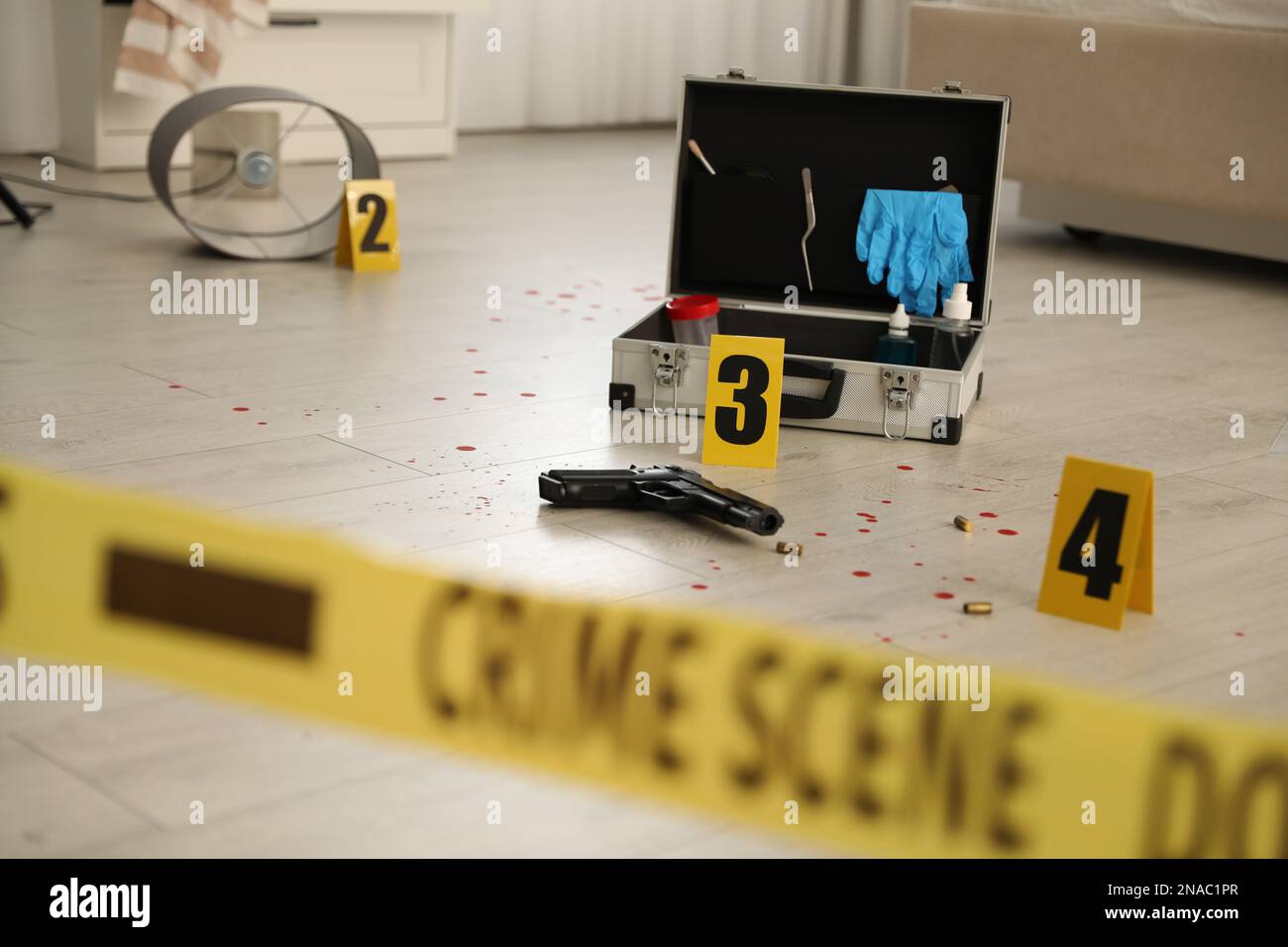 Crime scene markers, gun and criminologist case on floor in room Stock ...