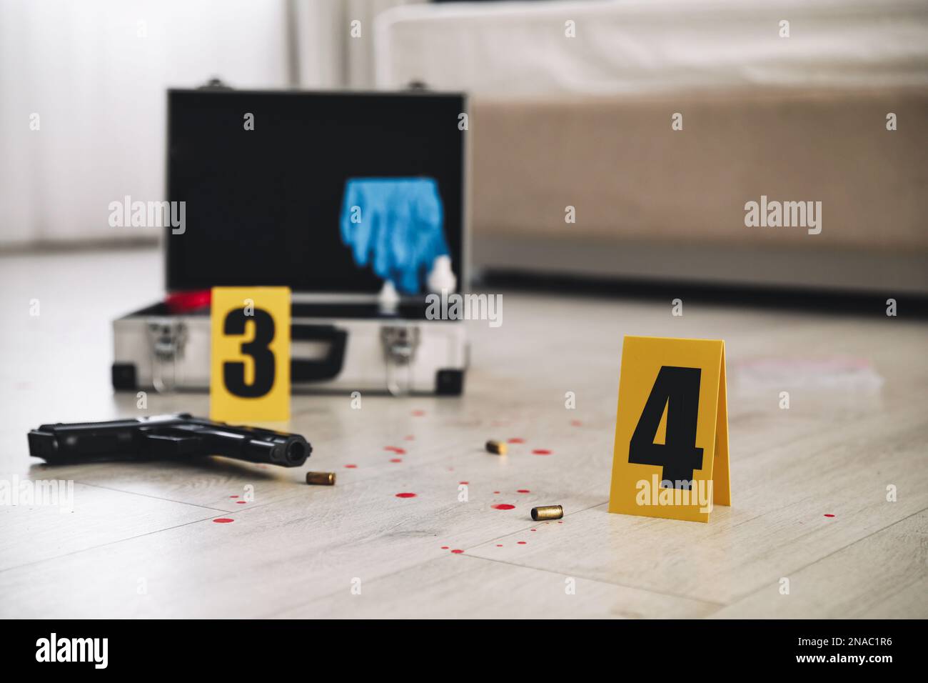 Crime scene markers, gun and criminologist case on floor in room Stock ...