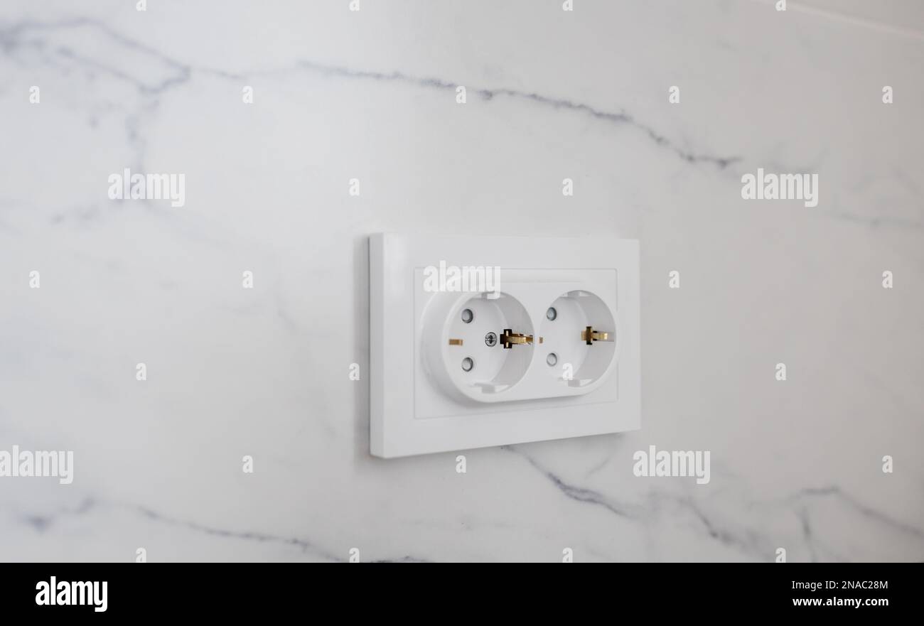 Electrical outlets mounted on wall. two white European high voltage ...
