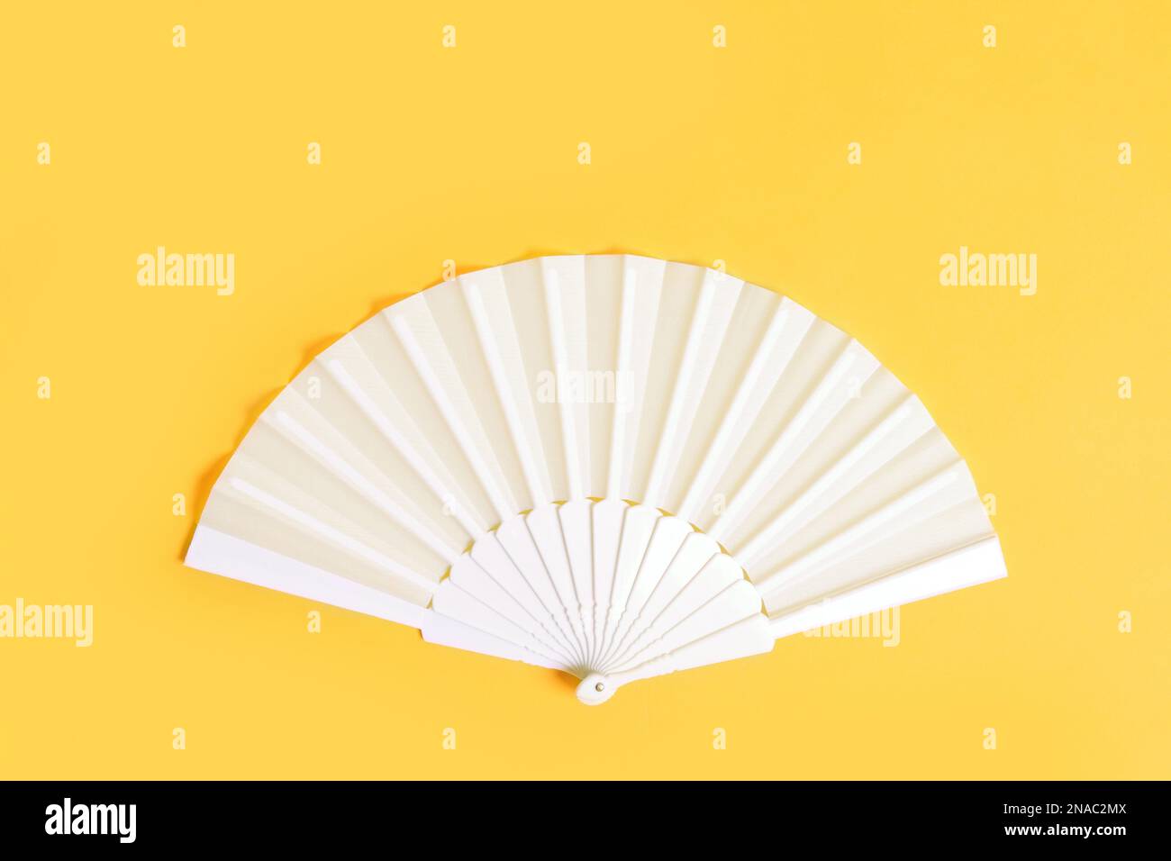 White hand fan on yellow background, top view Stock Photo - Alamy
