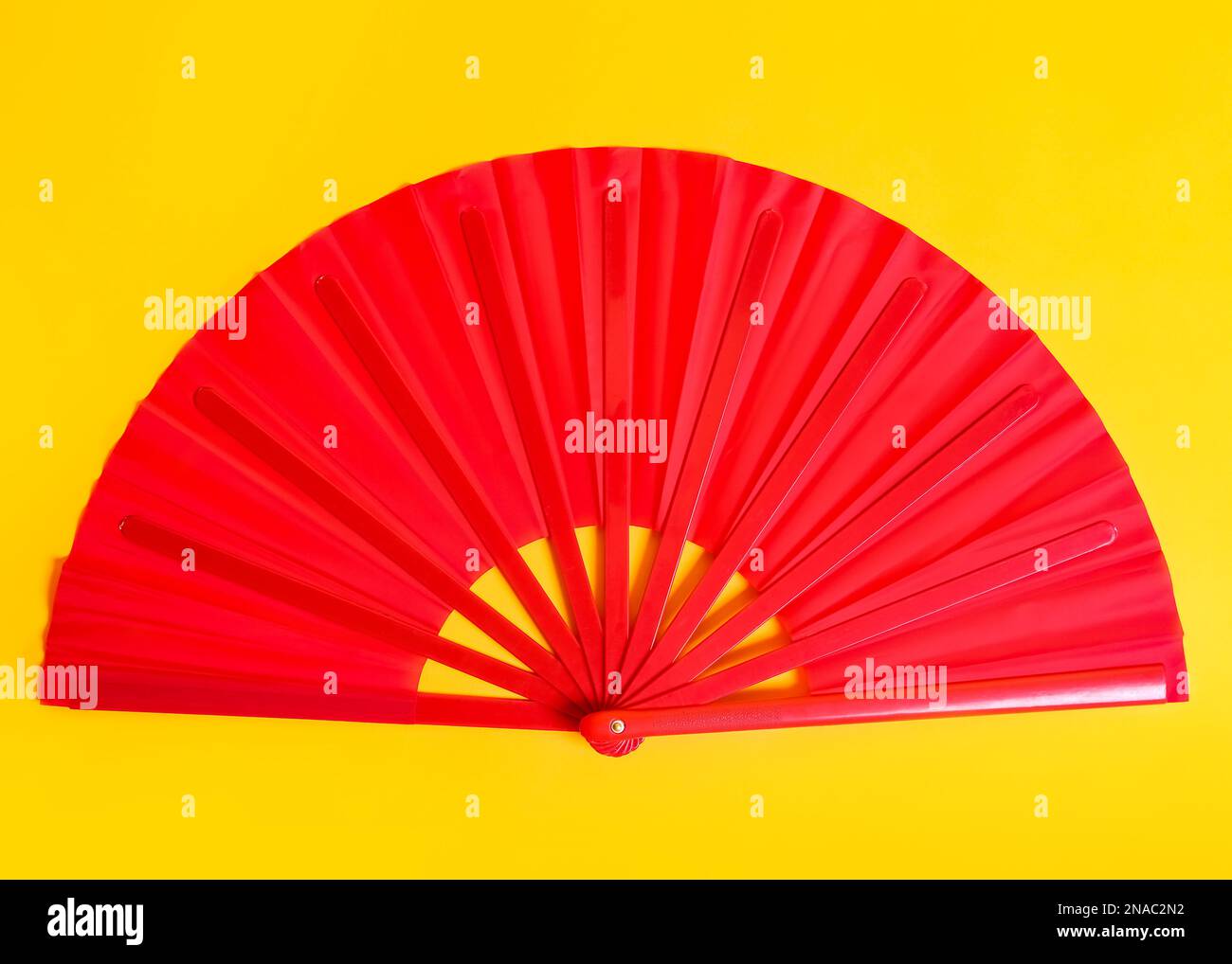 Red hand fan on yellow background, top view Stock Photo - Alamy
